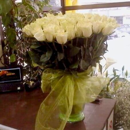 101 bela ruža u vazi sa zelenilom i dekoracijom