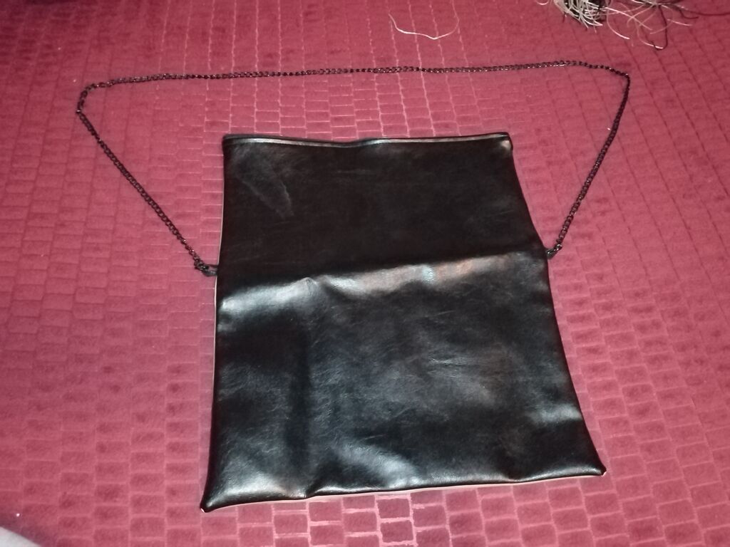 Crno zlatna pismo torba sa lancem preko ramena. Jednom korištena. Za