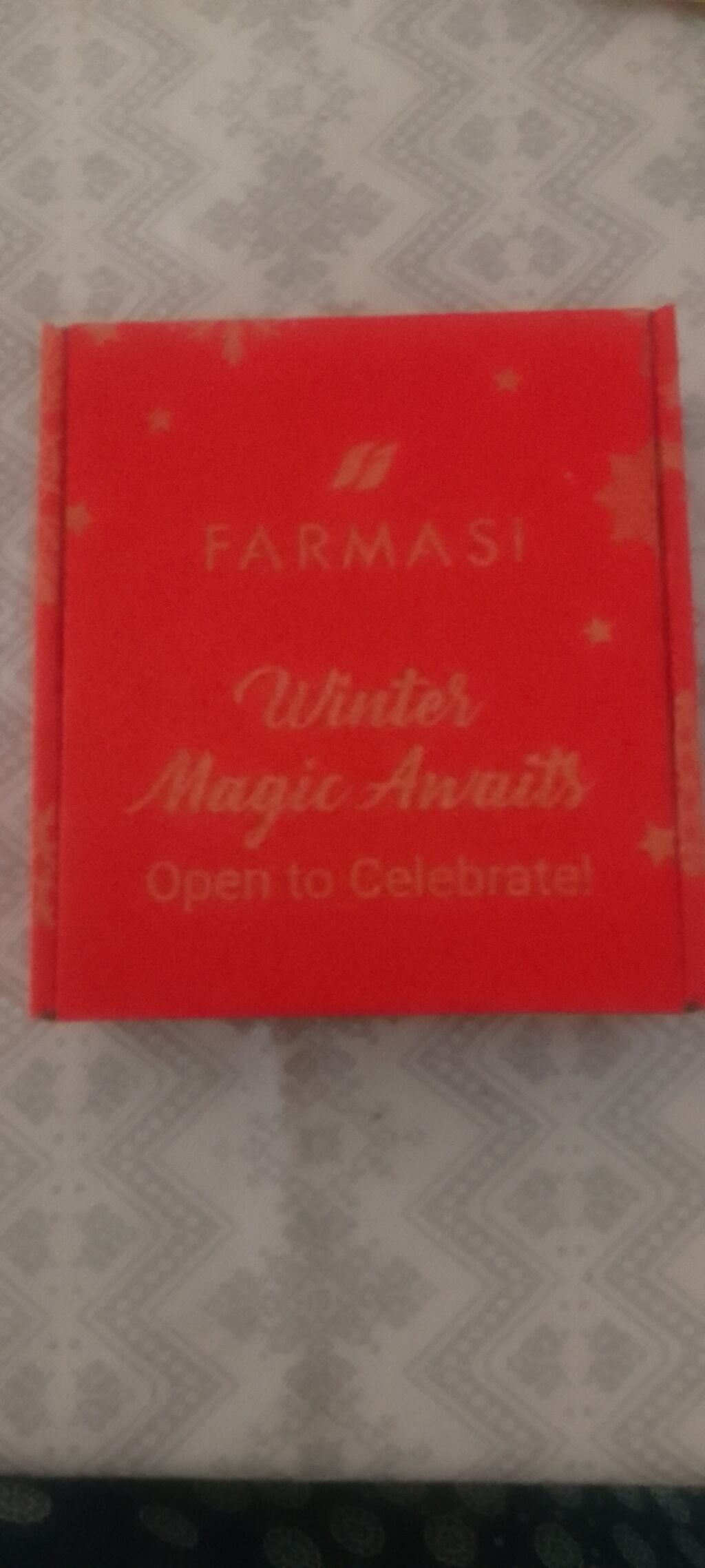 Kutija brenda Farmasi sa natpisom "Winter Magic Awaits. Open to