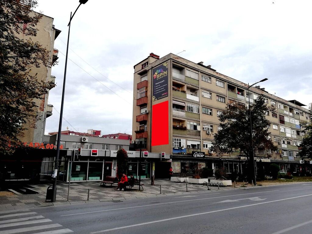 Veliki bilbord postavljen na fasadi zgrade. Bilbord je pravougaonog