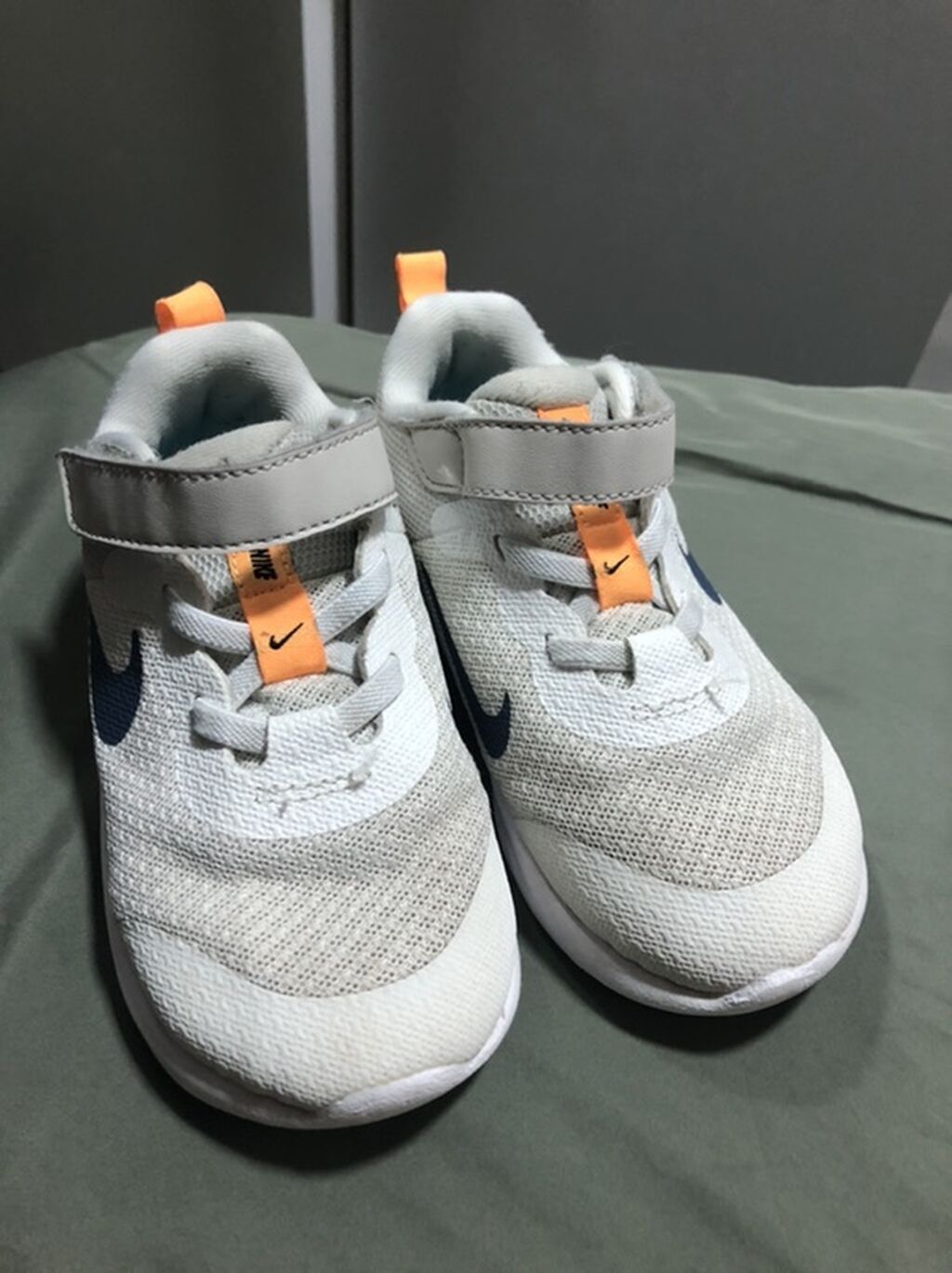 Dečije patike Nike – bele sa tamnoplavim Swoosh logoom i narandžastim