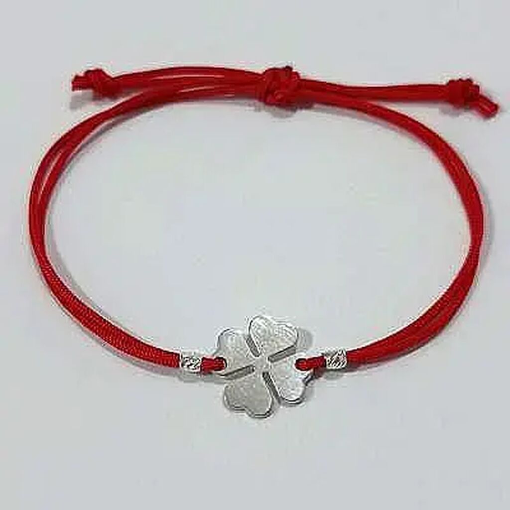 Four-leaf clover bracelet is handmade from red string and silver