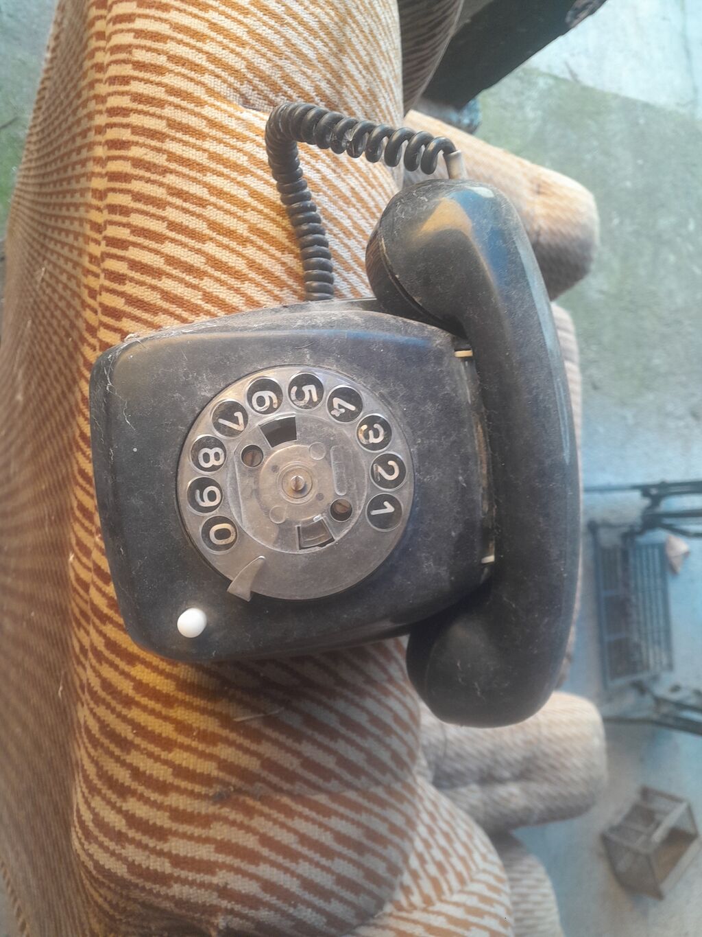 Retro fiksni telefon sa brojčanikom (rotacioni dial), crne boje. -
