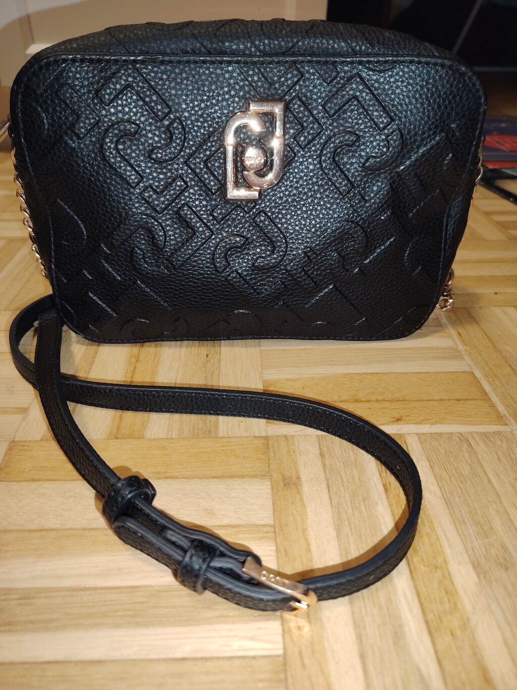 Crna crossbody torba sa utisnutim monogram uzorkom i zlatnim