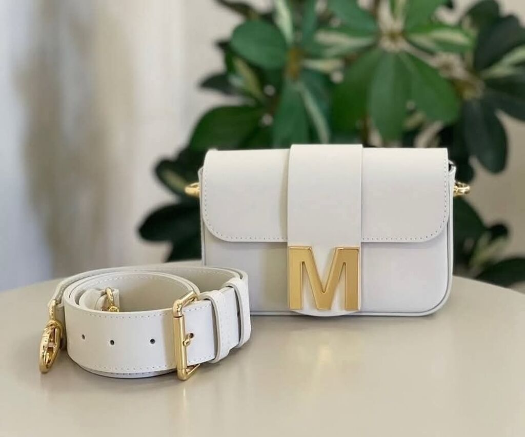 Ženska crossbody torba sa širokim kaišem i metalnim slovom “M” -