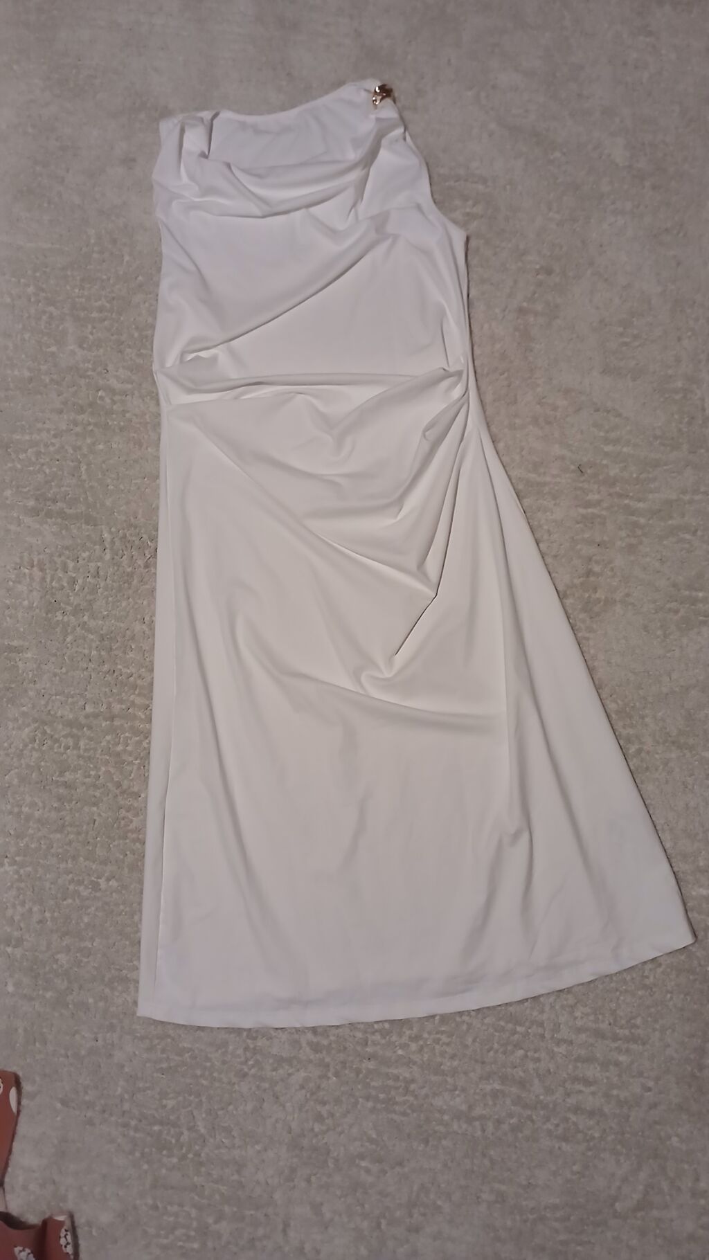 Elegantna bela haljina bez rukava, midi dužine. Asimetrični kroj sa