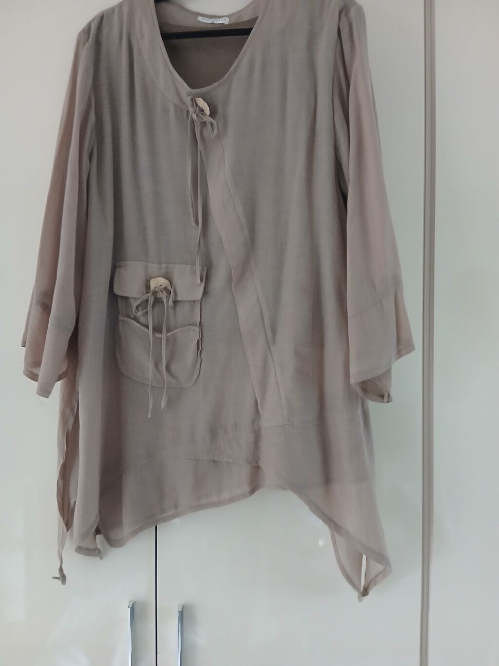 Elegantna ženska bluza boje taupe/svetlo bež. Detalji: - Lagana