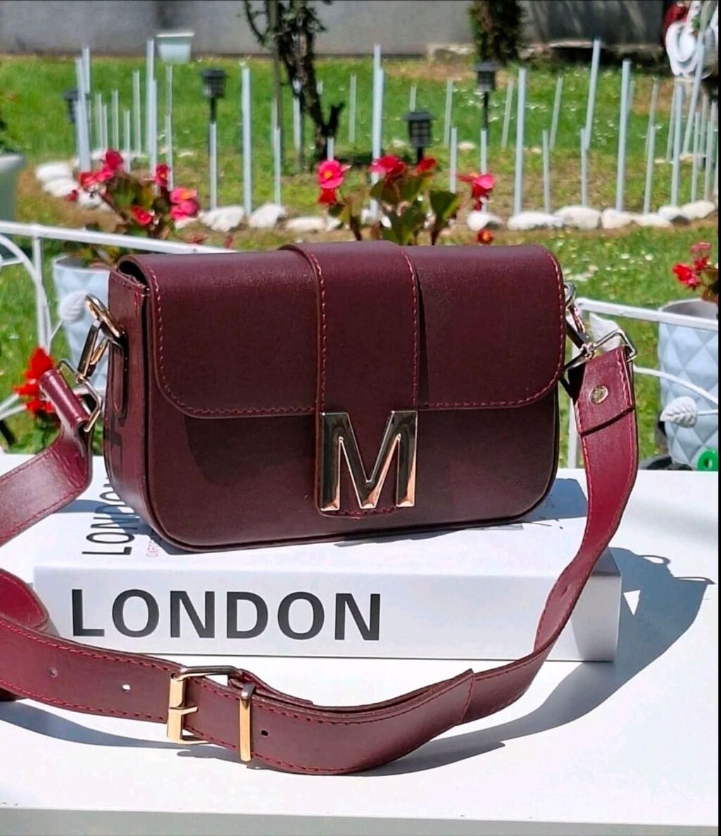 Ženska crossbody torba sa širokim kaišem i metalnim „M“ detaljem -