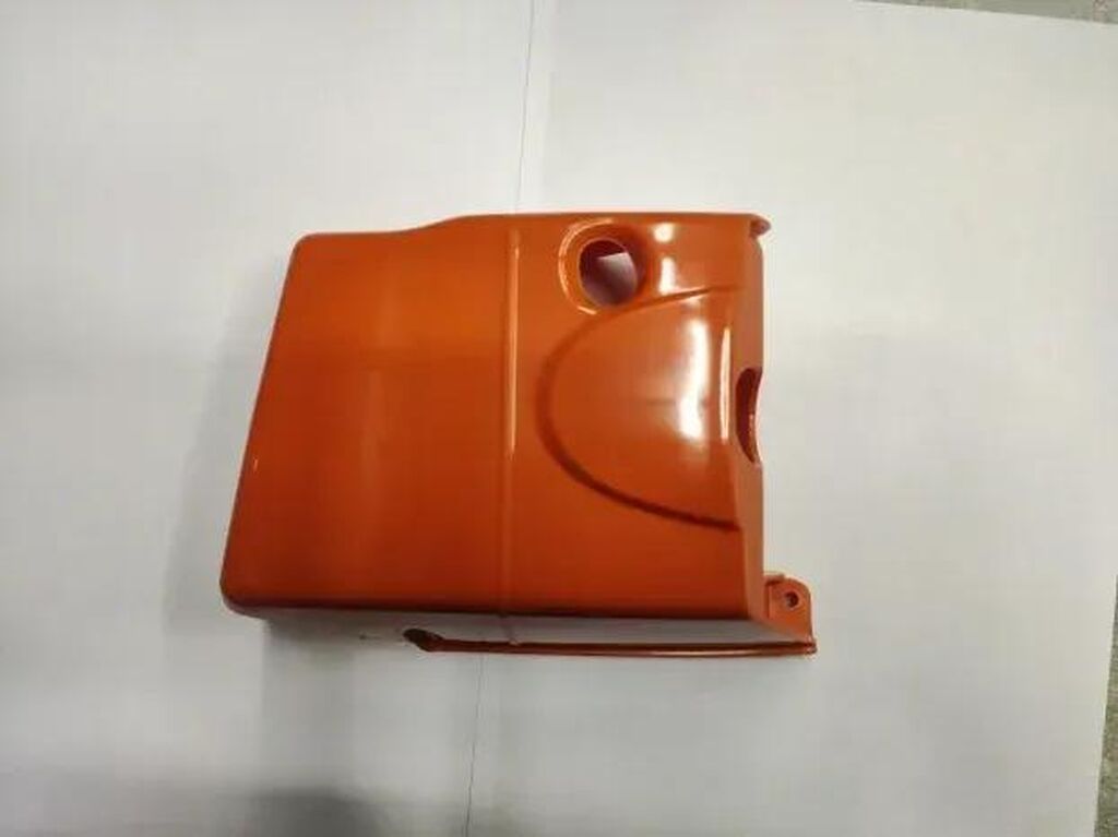 Narandžasti poklopac motora za motornu testeru, izrađen od sjajne