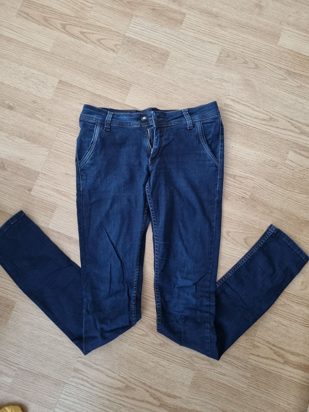 Jeans tamnoplave boje sa klasičnim dizajnom. Imaju ravan kroj