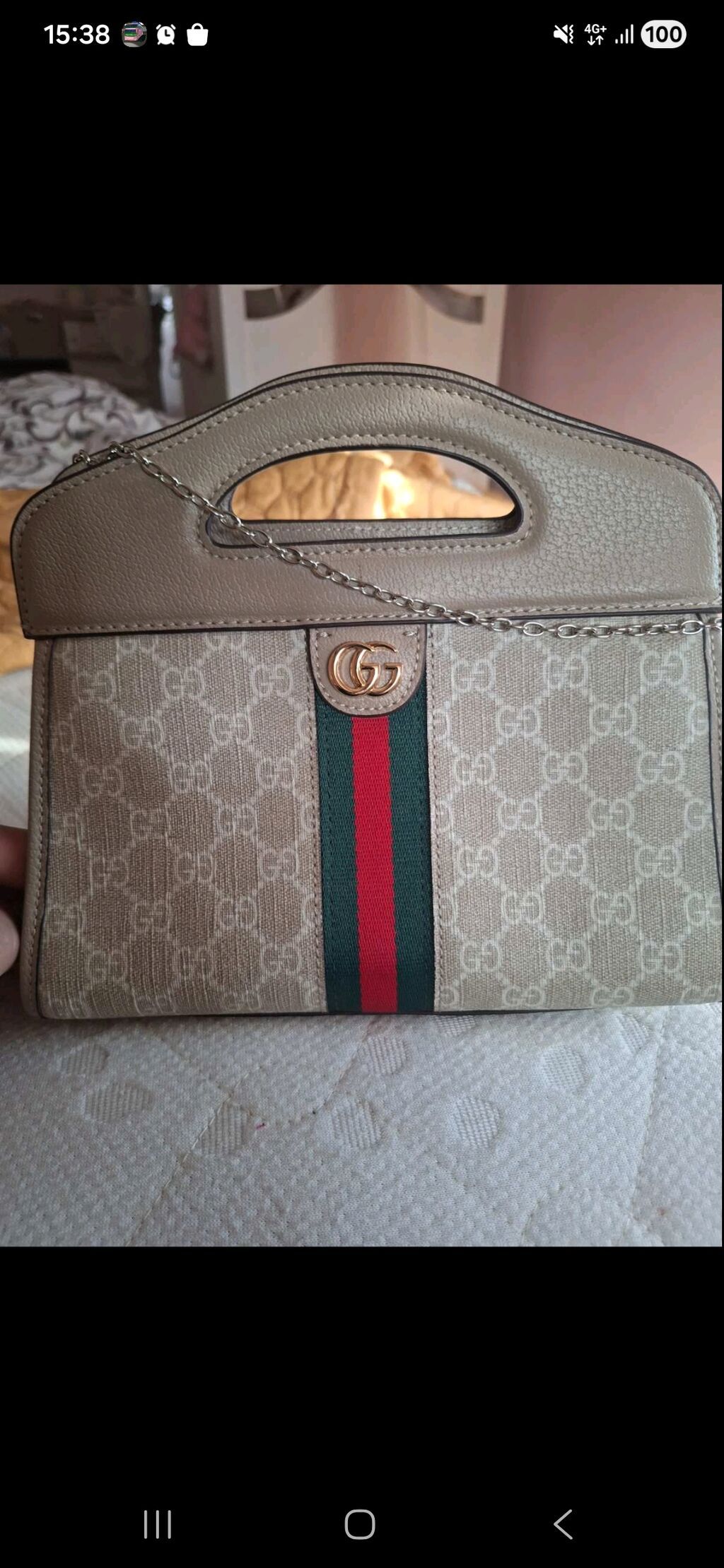 Elegantna torbica sa ručkom i lancem preko ramena. Model u bež