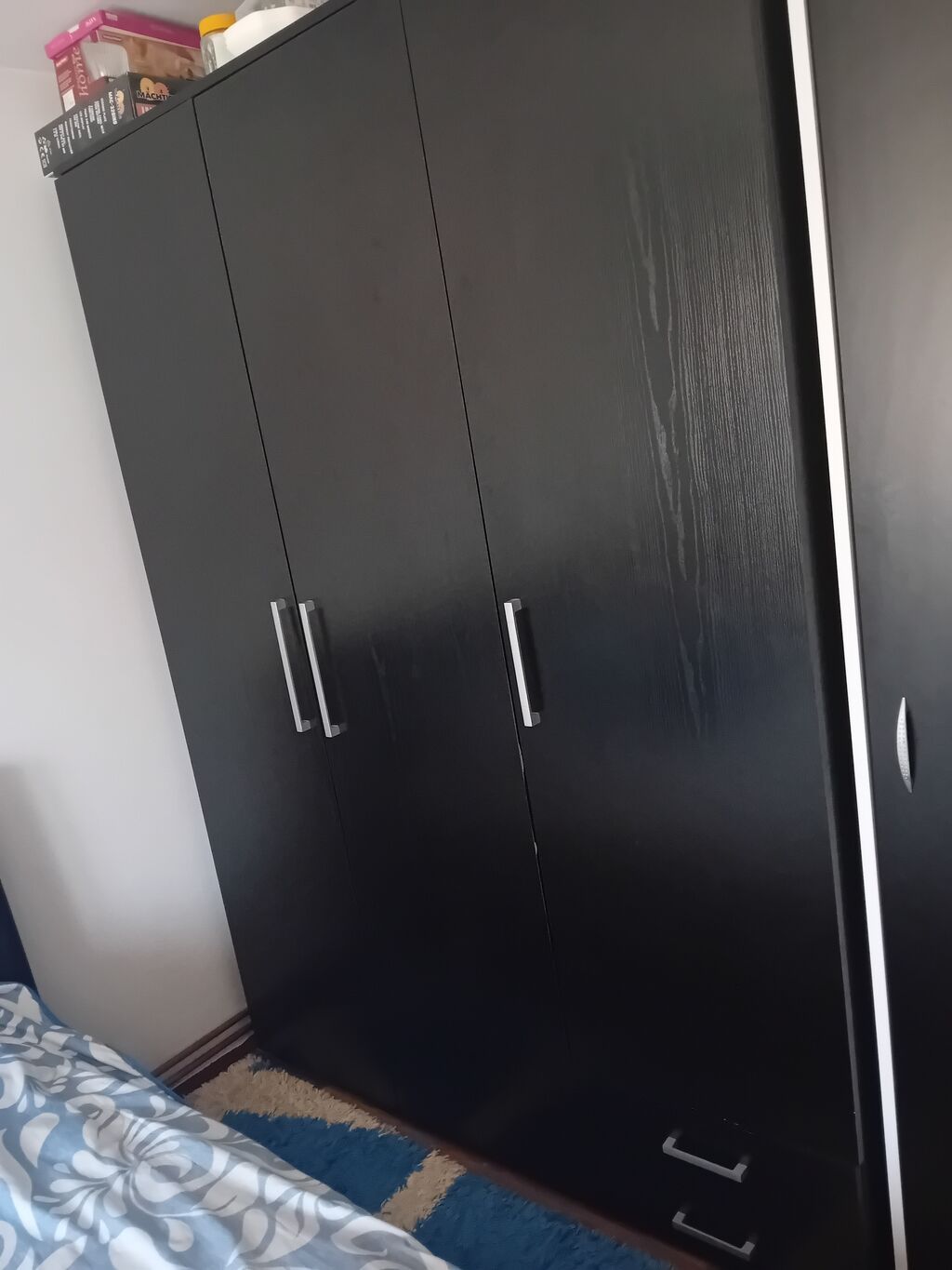 Troslojni garderober od tamnog drveta (verovatno iverica/MDF) sa