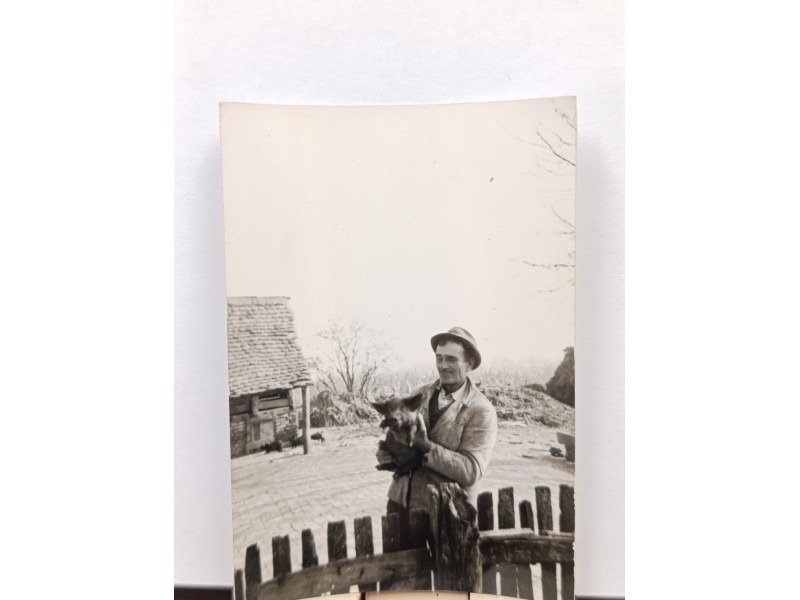 Vintage fotografija covek drži prase