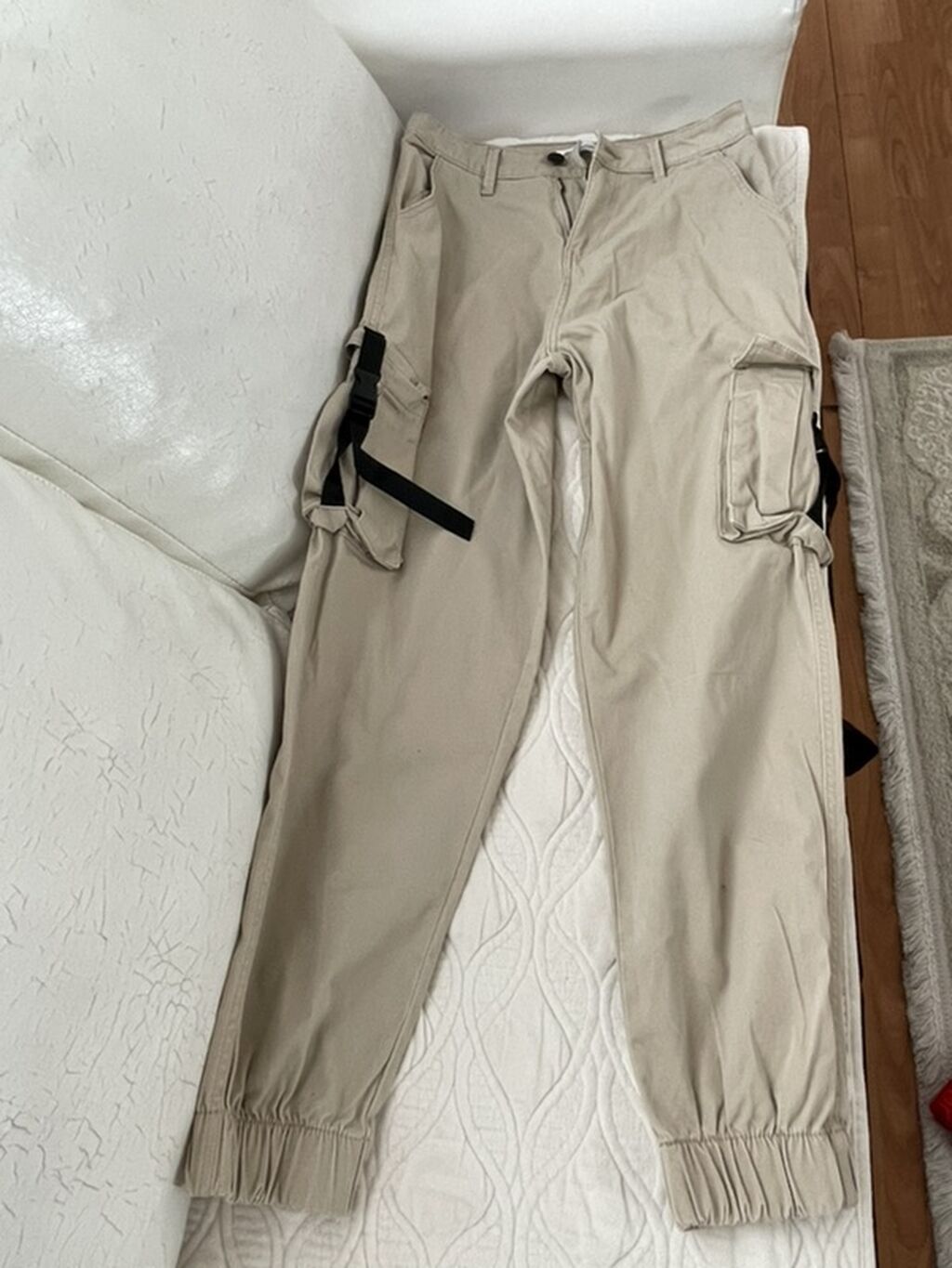 Bež cargo pantalone sa elastičnim ranflama na nogavicama. - Kroj