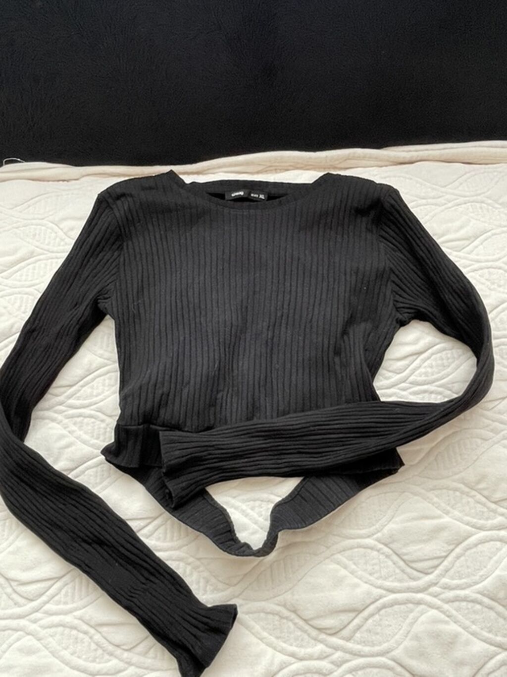Crni ženski top sa dugim rukavima i otvorenim donjim delom (wrap/strap