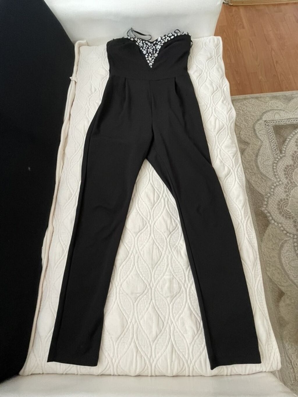Elegantni crni ženski kombinezon bez rukava. Gornji deo je korset