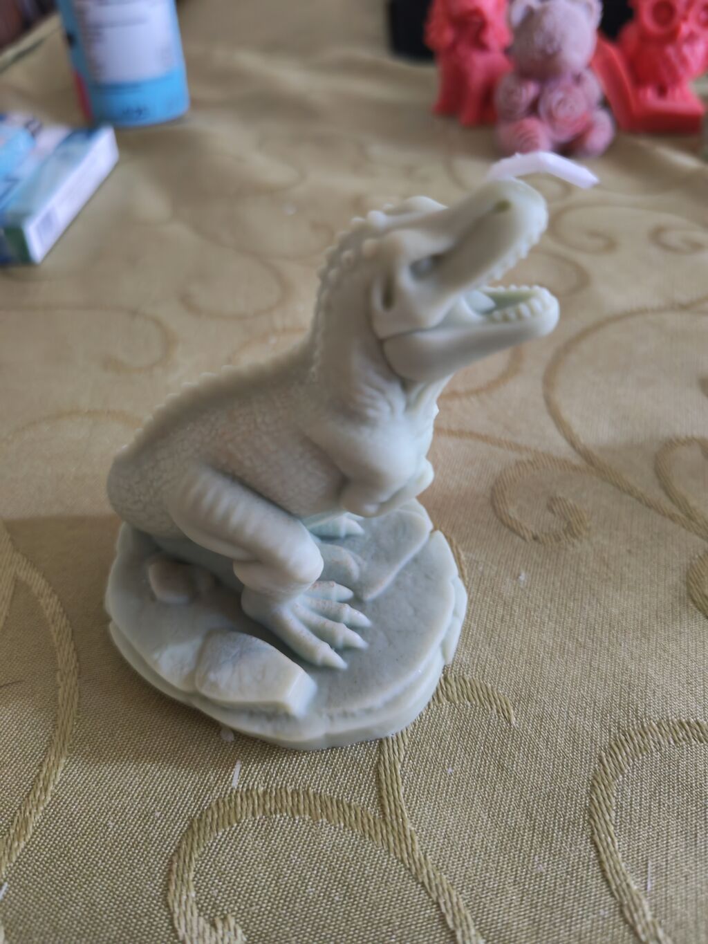 Dekorativna figurica dinosaurusa – detaljno modeliran reptil u sedećem