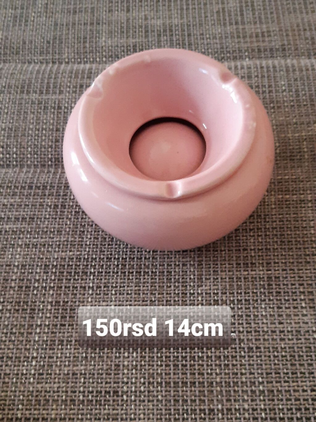 Keramička pepeljara, okruglog oblika, u nežno roze boji. Na obodu ima