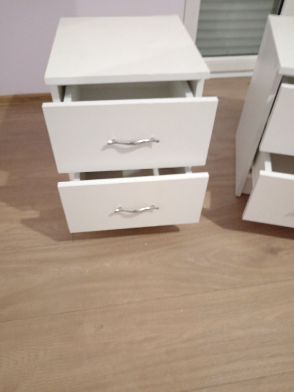 Set od dve noćne komode – bela boja, moderan minimalistički dizajn. -