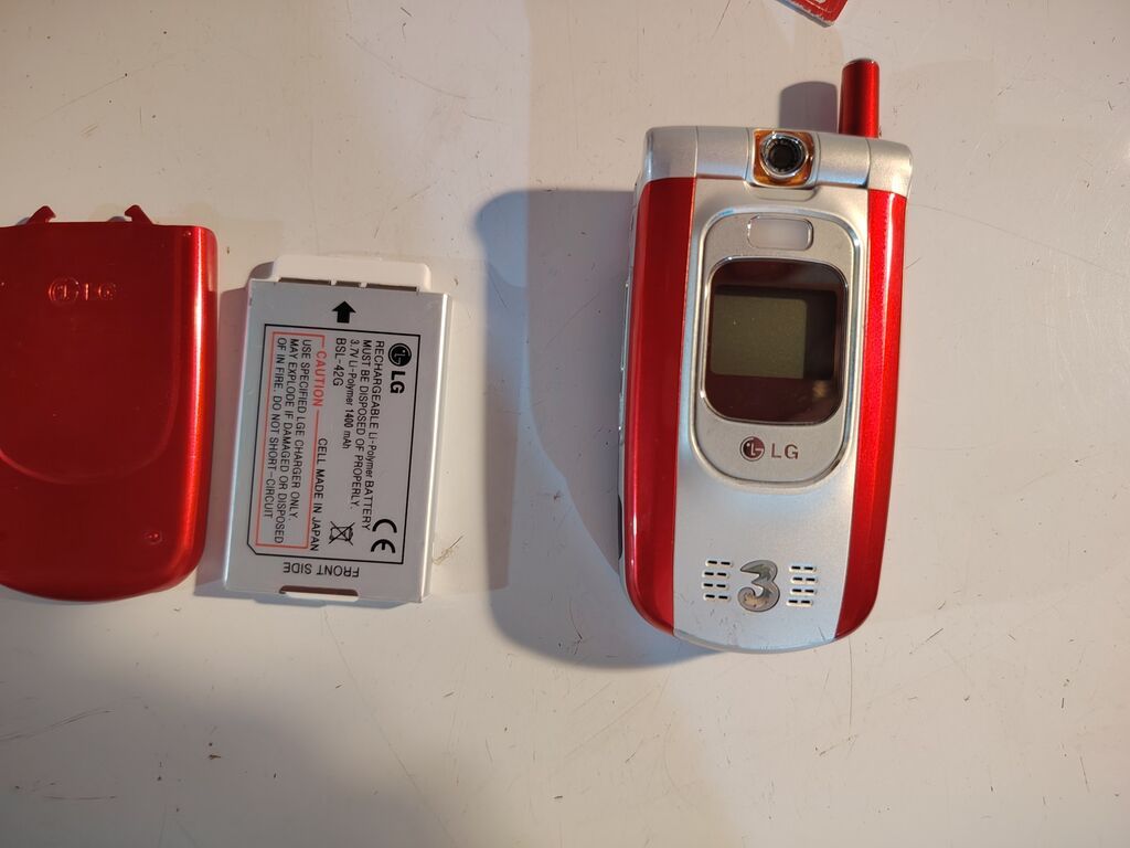 LG preklopni mobilni telefon (crveno‑srebrni), sa spoljnim ekranom i