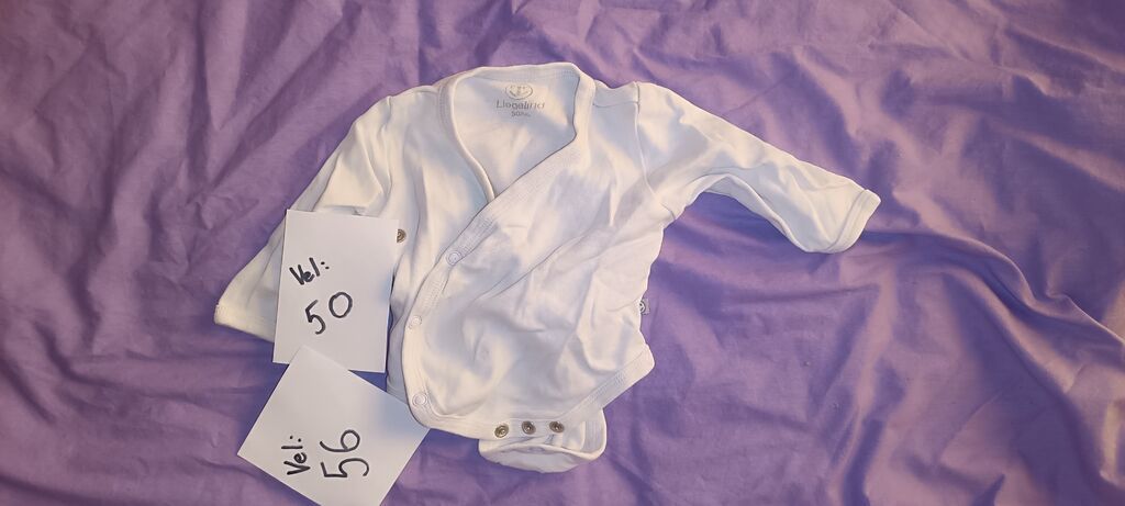 Bebi bodi na preklop, dugih rukava, bele boje. Model se kopča sa