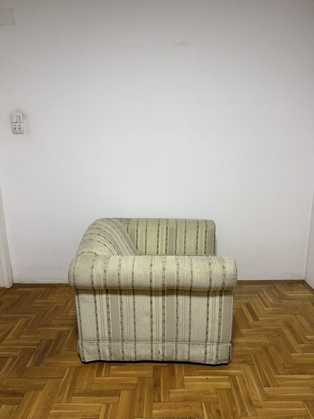 Preudobna fotelja sa klasičnim zaobljenim naslonima i valjkastim